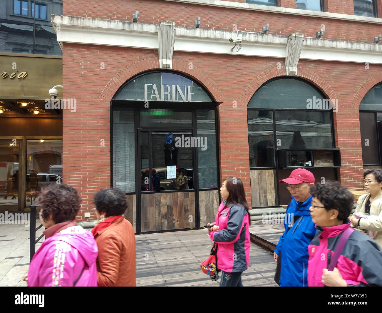 Pedestrians walk past a chain store of French bakery Farine temporarily ...