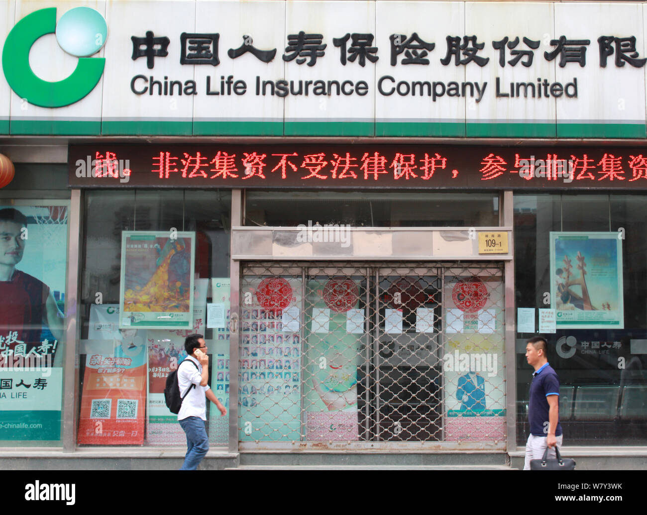 --FILE--Pedestrians walk past a branch of China Life Insurance Company ...
