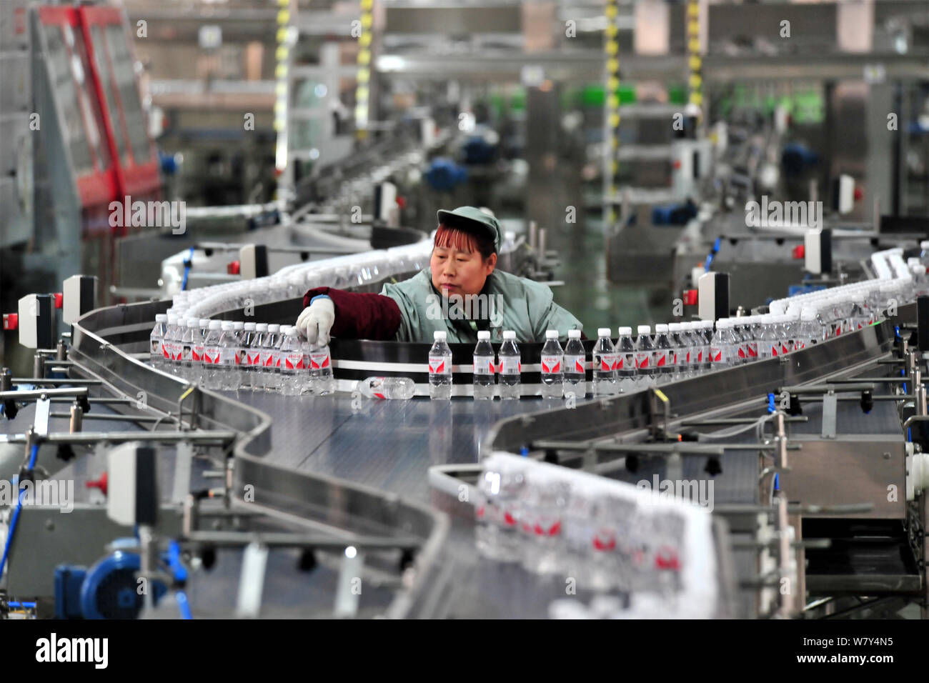 --FILE--A Chinese worker checks bottles of Wahaha purified water on the ...