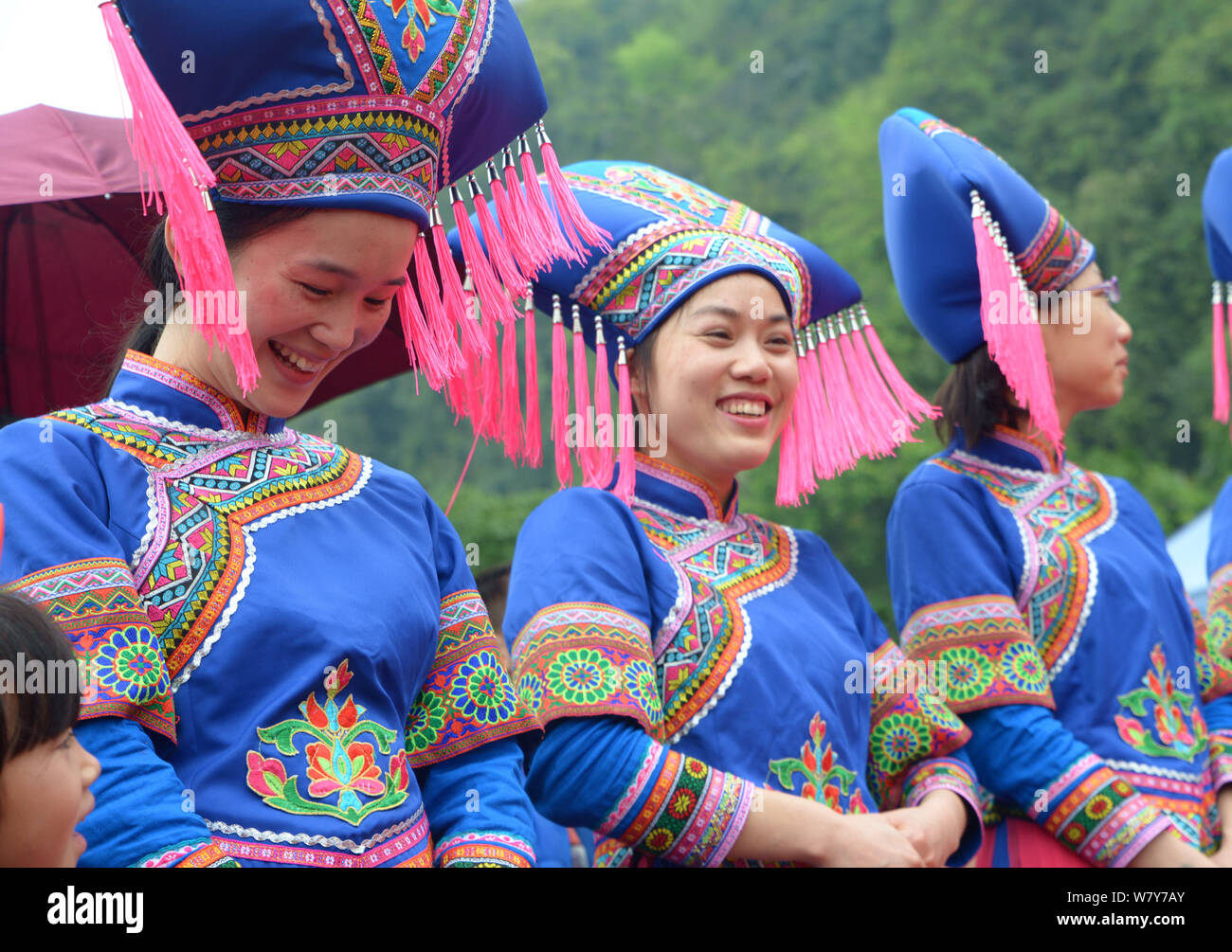 Chinese girls of Zhuang ethnic group dressed in traditional costumes ...
