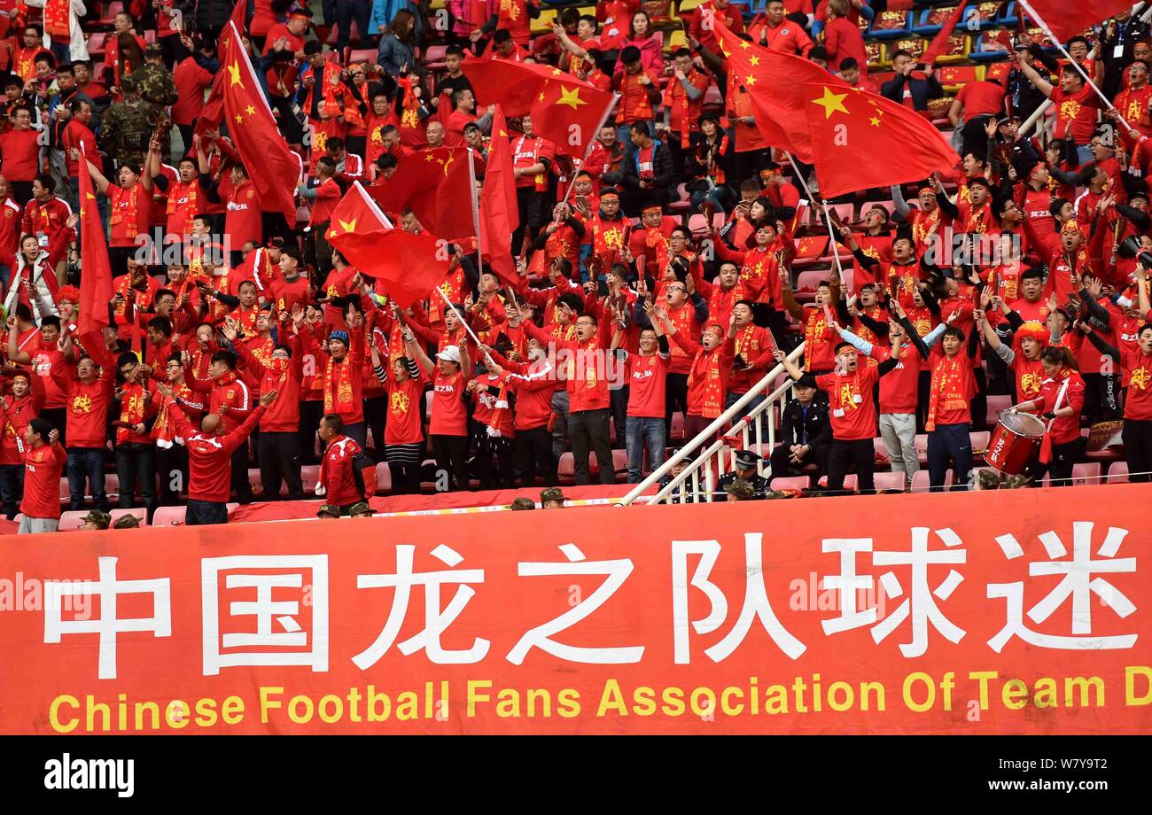 Chinese football fans hold up Chinese national flags to show his ...