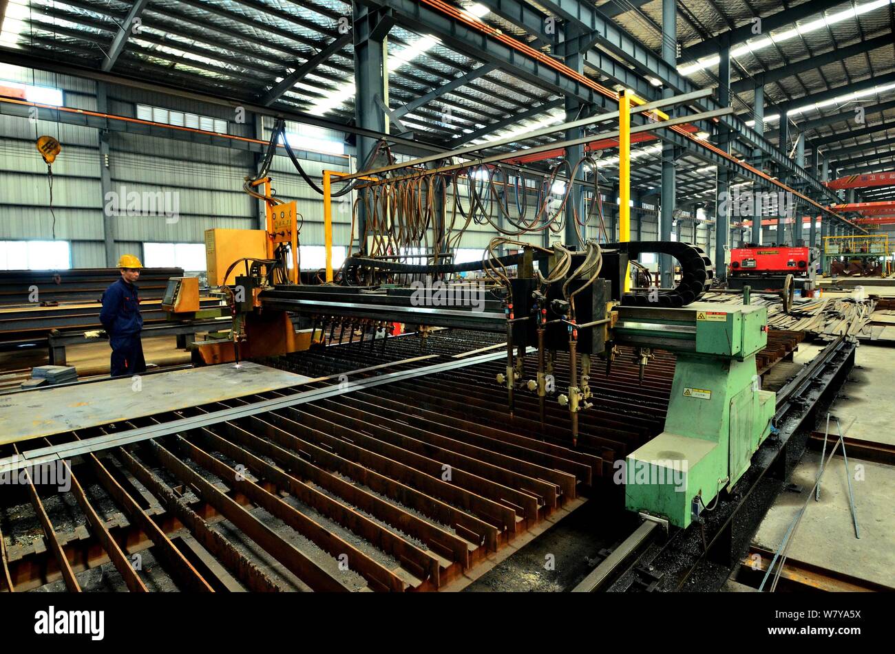 A Chinese worker surveys the production of garage equipment at a ...