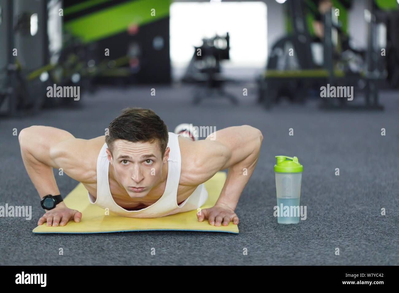 Front view of young athlete man portrait doing push up exercise at the ...