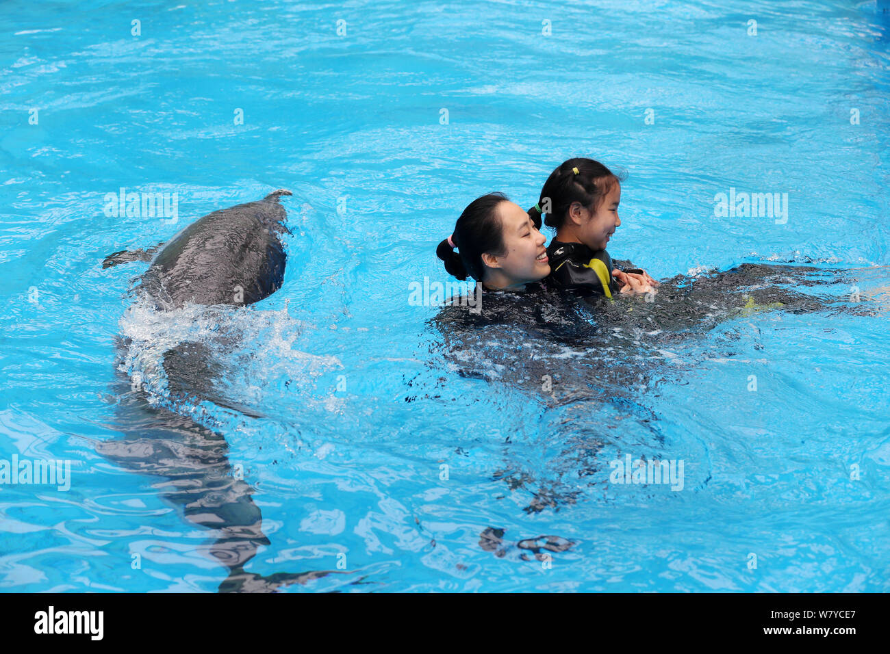 Chinese autistic girl Chenchen interacts with a dolphin under the help ...