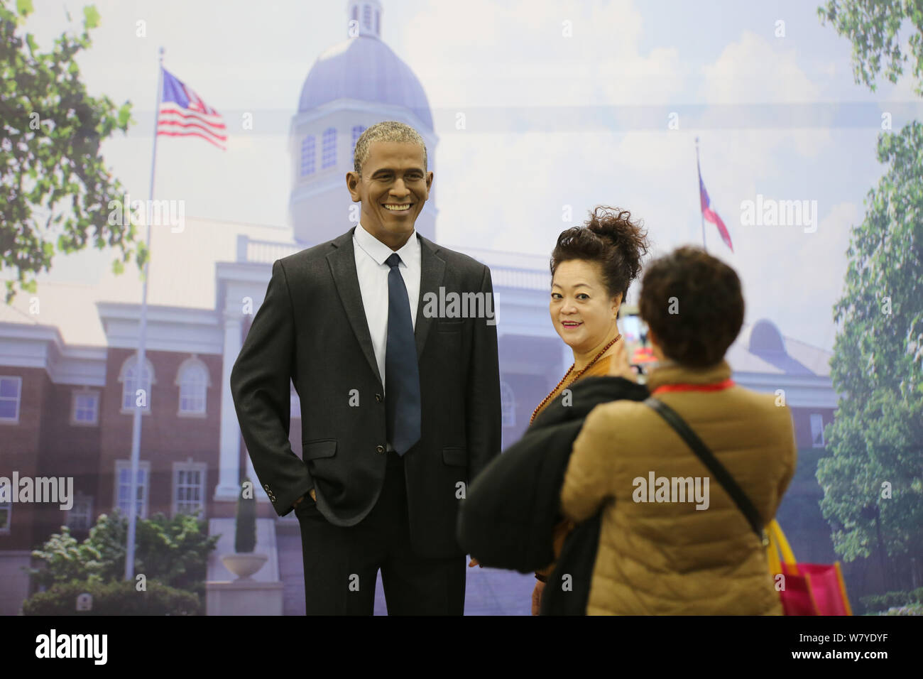 A visitor poses for photos with a wax figure of former U.S. President ...