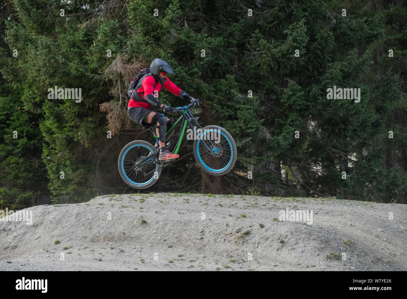 Mtb biker jumping on a dusty jump Stock Photo - Alamy