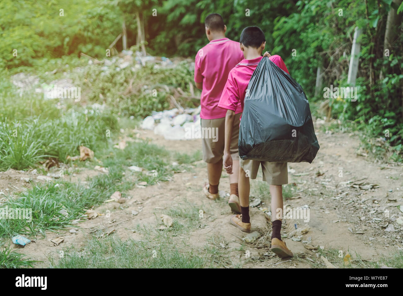 Male Students help to remove rubbish from the classroom to pile waste ...