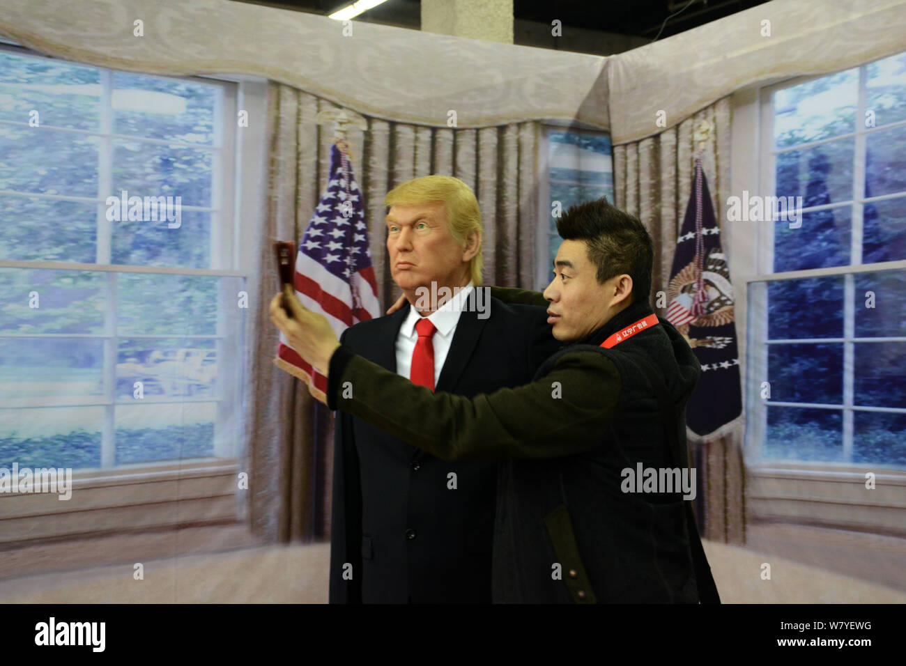 A visitor poses for selfies with a wax figure of new US President ...