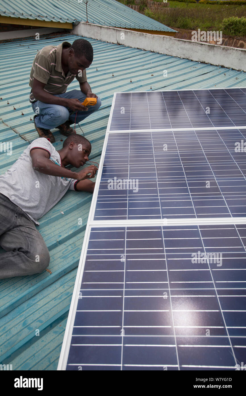 Solar energy technicians checking panel installation, Rwanda, April ...