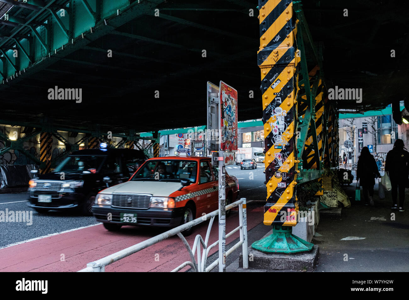 Cars and pedestrians under a bridge crossing in Akihabara, Tokyo, Japan ...