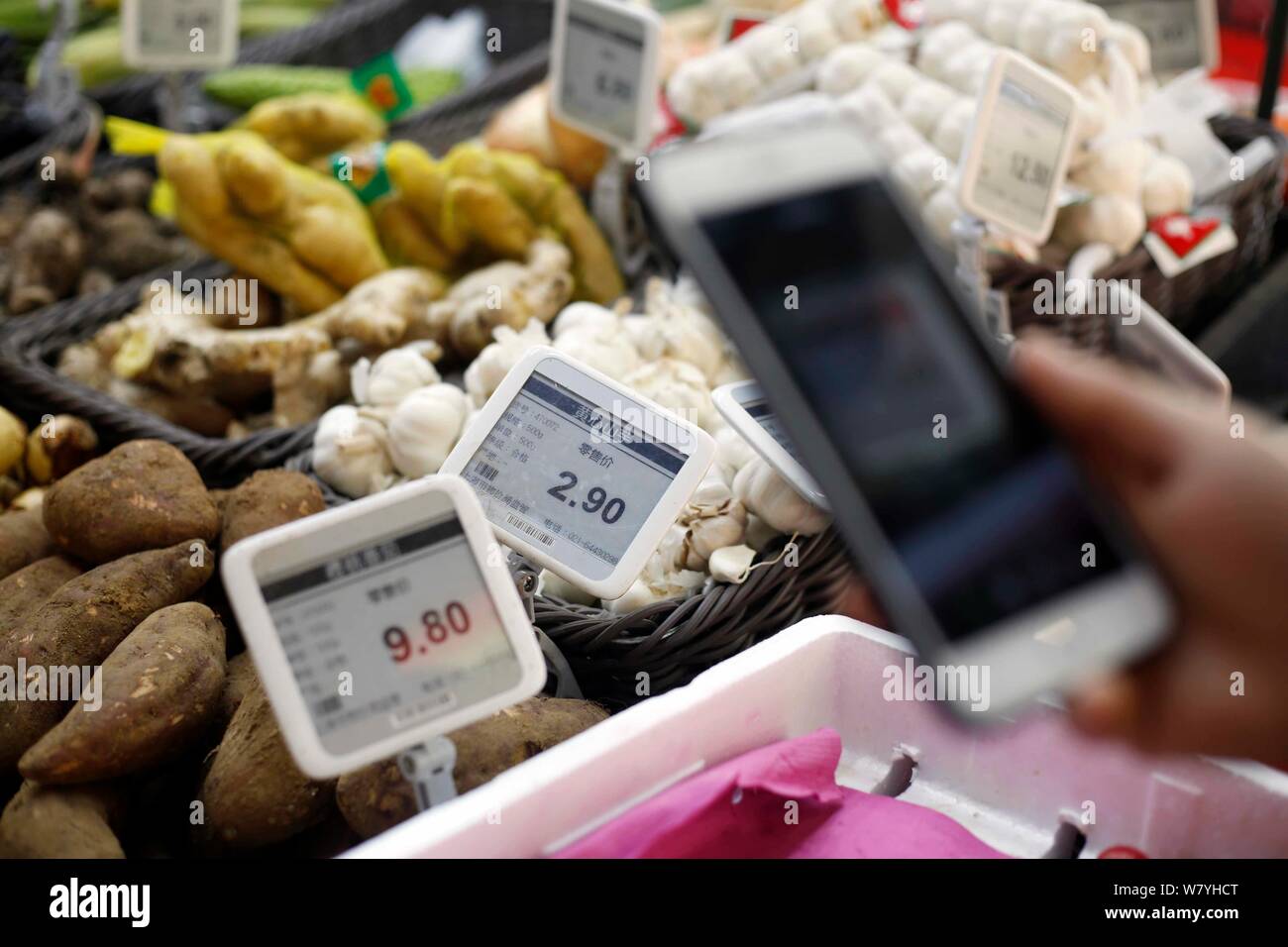 A Chinese customer uses her smartphone to scan the QR code on ...