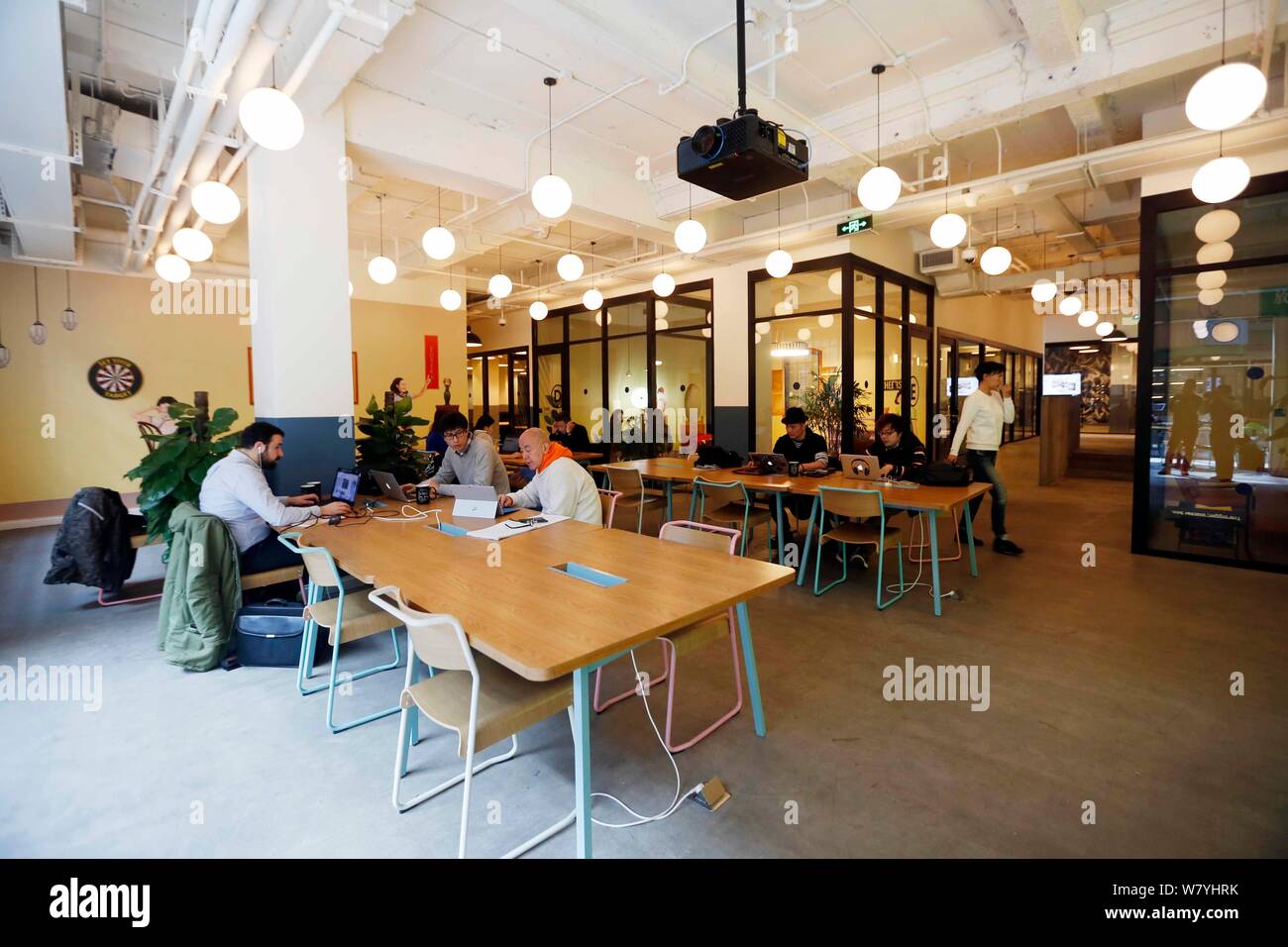 Chinese employees work at a WeWork co-working space in Shanghai, China ...