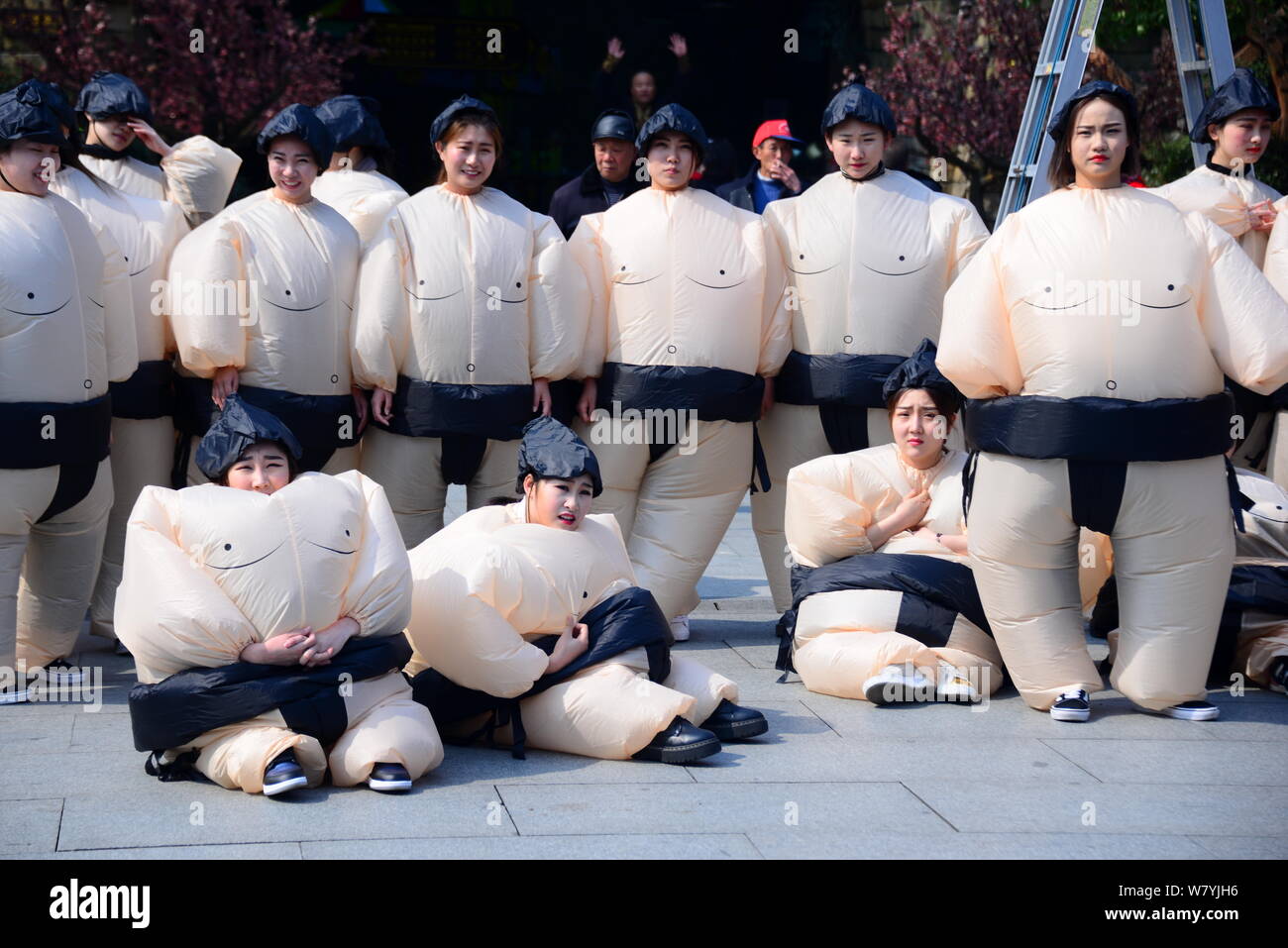 Chinese women dressed in inflatable sumo-wrestler costumes pose at ...