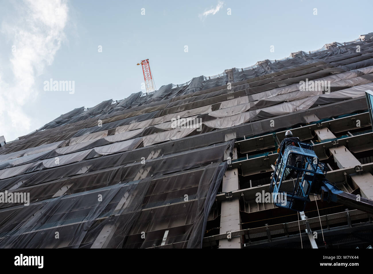 Worker inspecting development progress of a high rise building in Tokyo ...