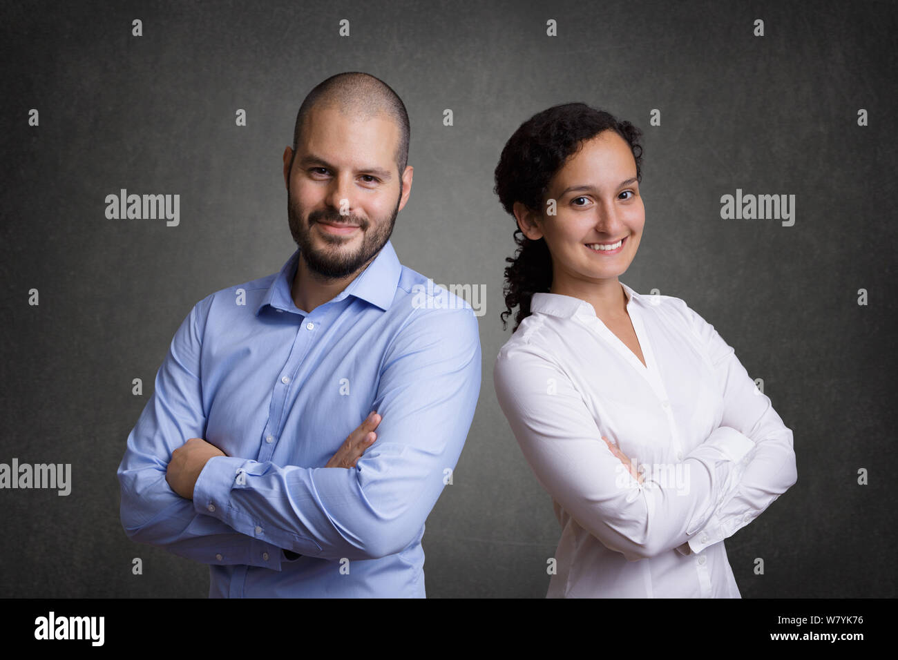Business Team standing in front of a grey blackboard background ...