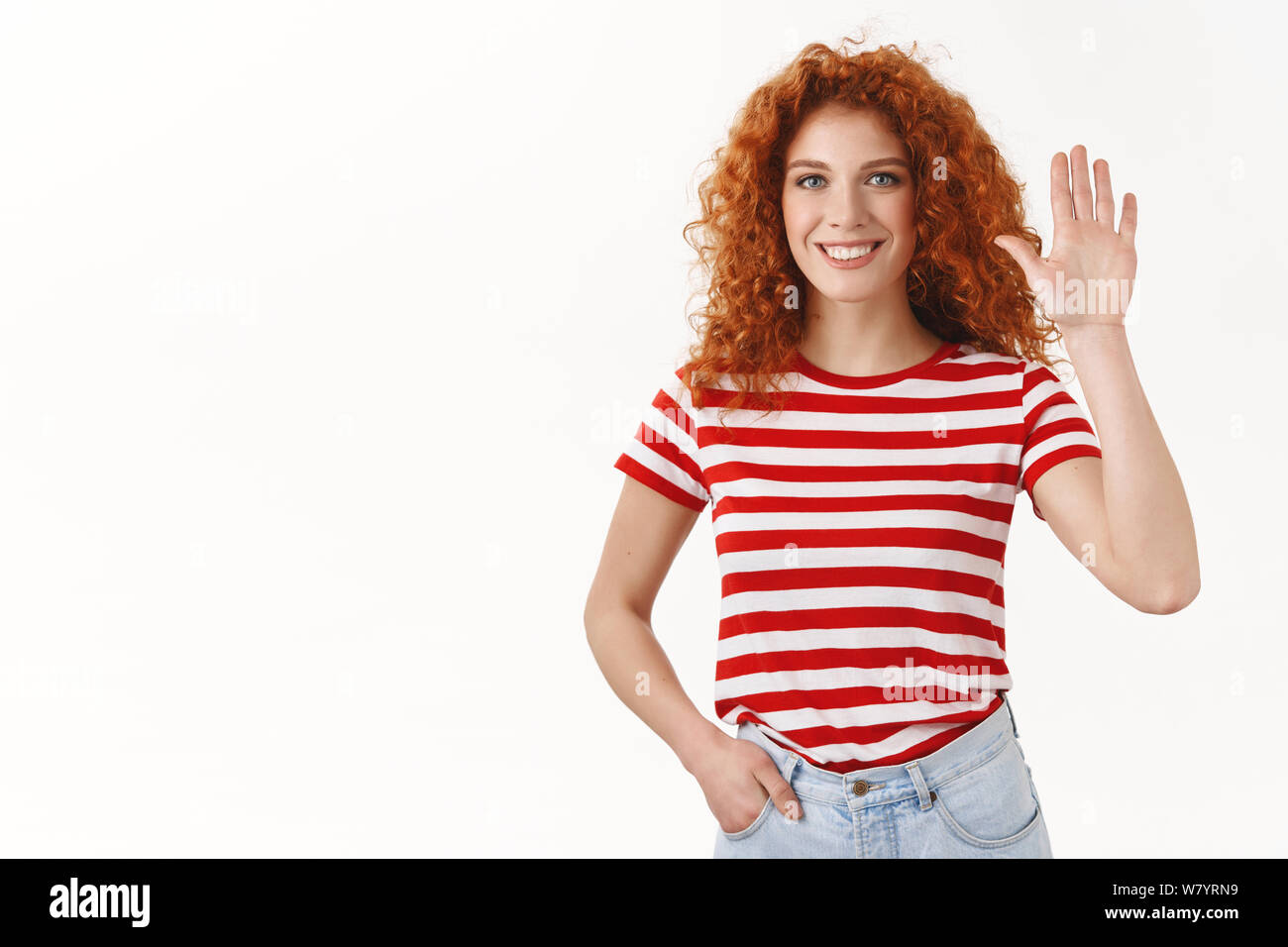 Redhead woman raising one hand waving palm greeting say hi joyfully ...