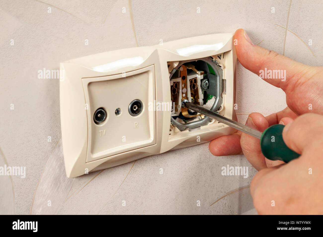Repair an electrical outlet in the wall of a house Stock Photo - Alamy