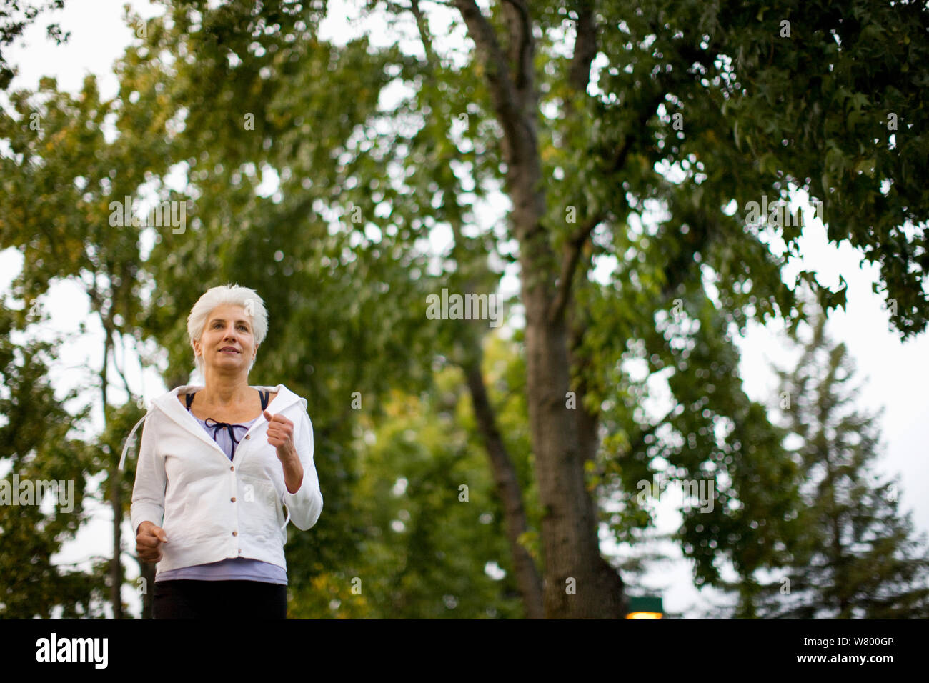 Mature woman running in a suburban park Stock Photo - Alamy
