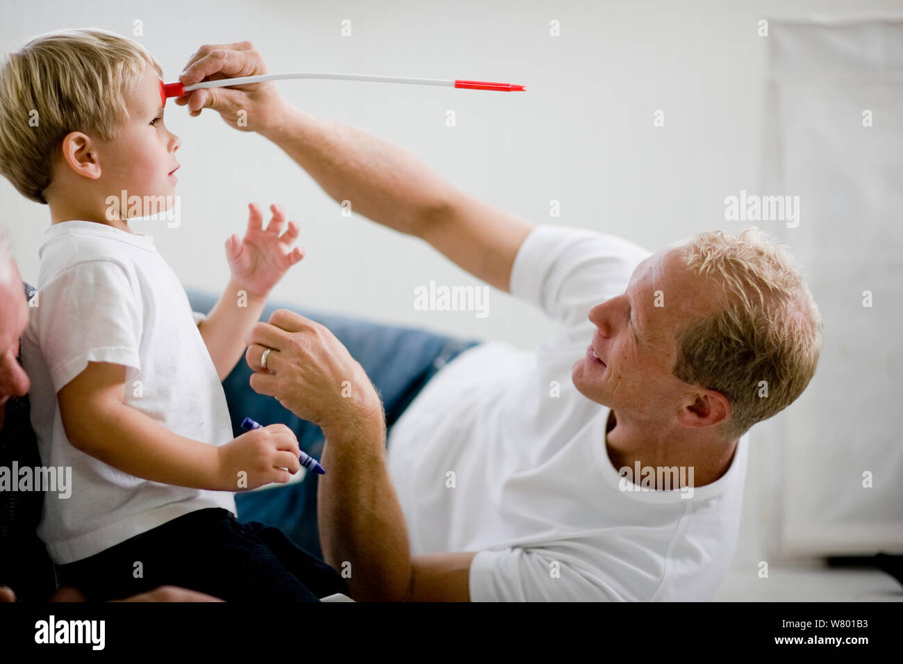 Man sticking toy arrow to son's head Stock Photo - Alamy