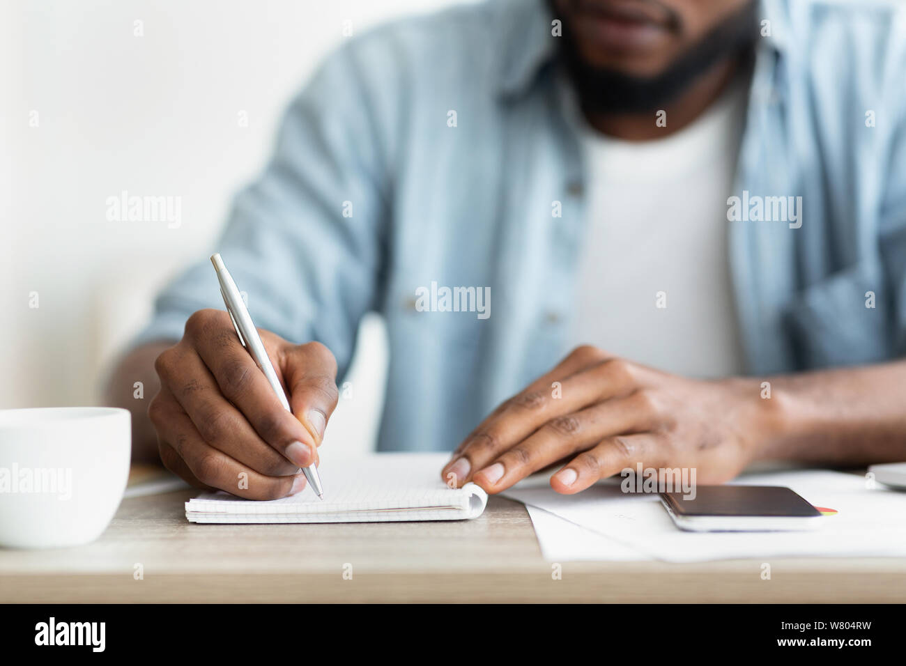 African american businessman writing down his plans to notepad Stock ...