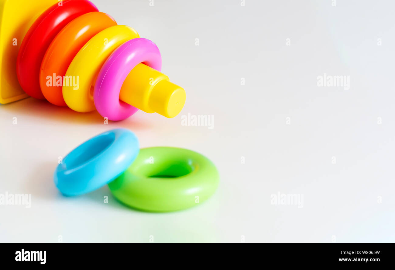 Plastic rings of various colors are stacked in a yellow plastic tower ...