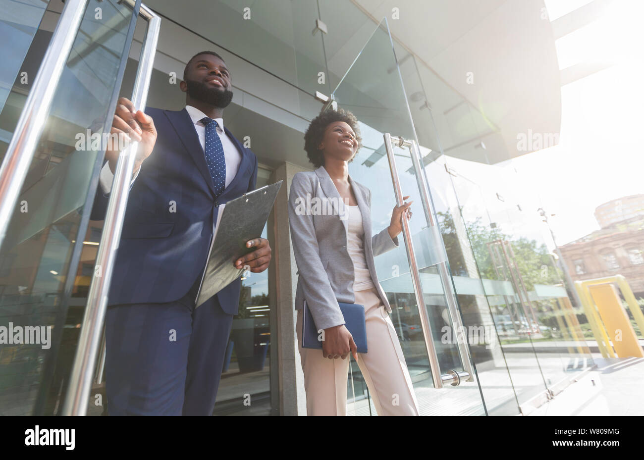 Confident african business people walking out of modern office center ...