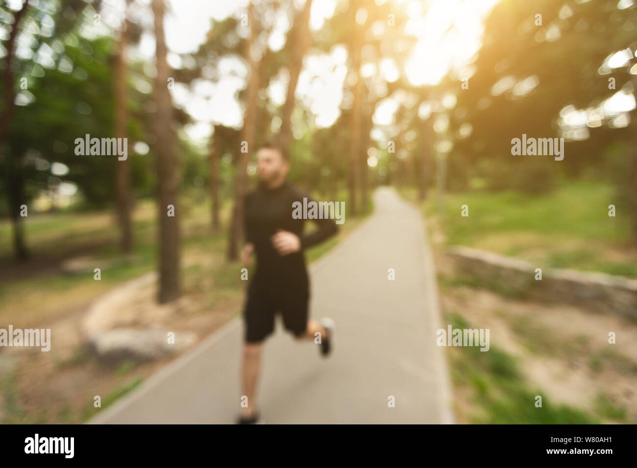Morning jogging background. Blurred shot of man running in city park ...