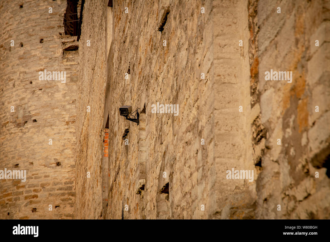 Security camera on medieval stone wall Stock Photo - Alamy