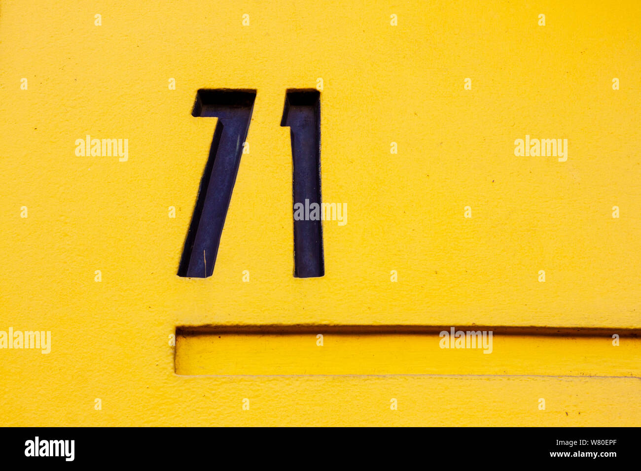Bold house number 71 in black on a bright canary yellow door with ...