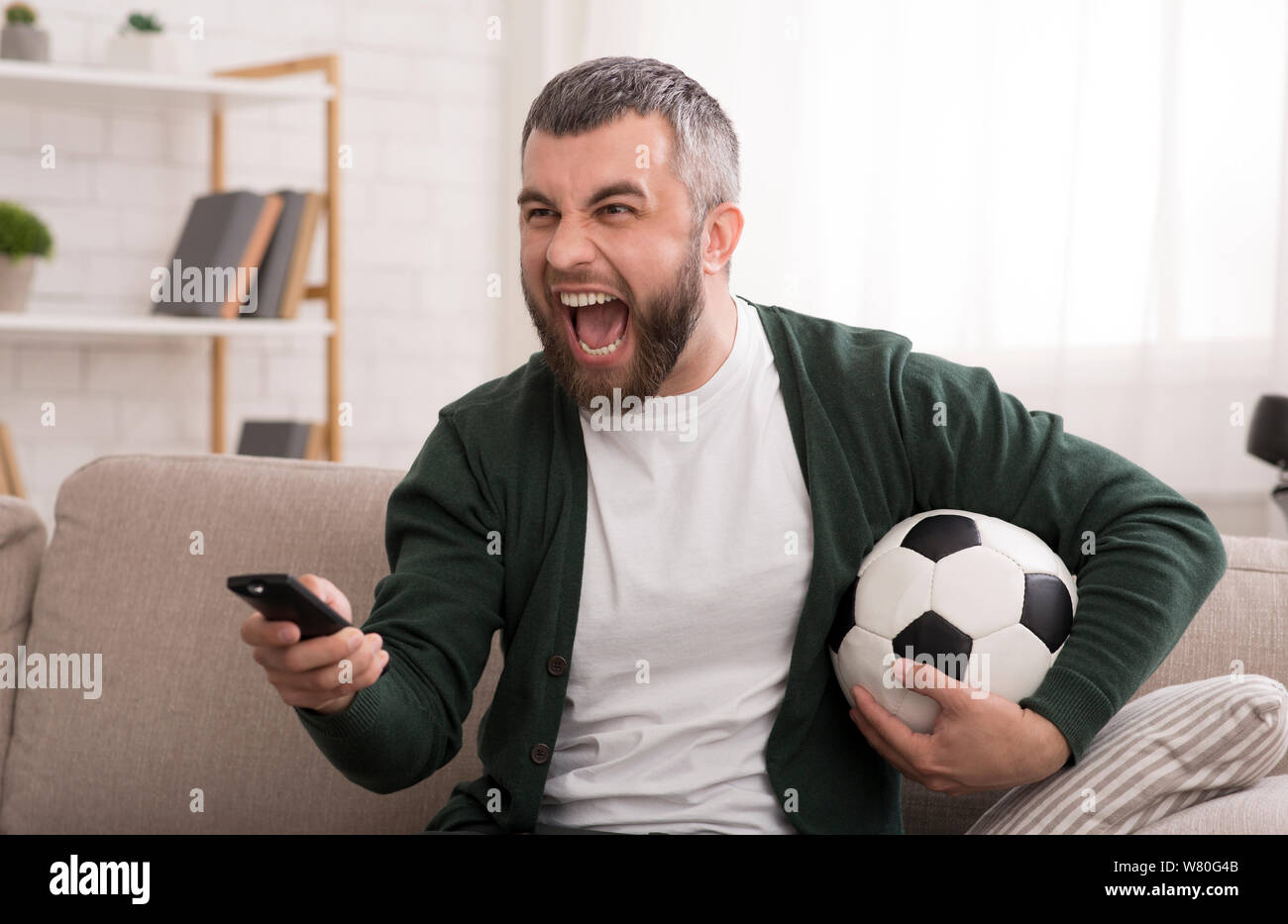 Angry caucasian man watching football game on TV Stock Photo - Alamy
