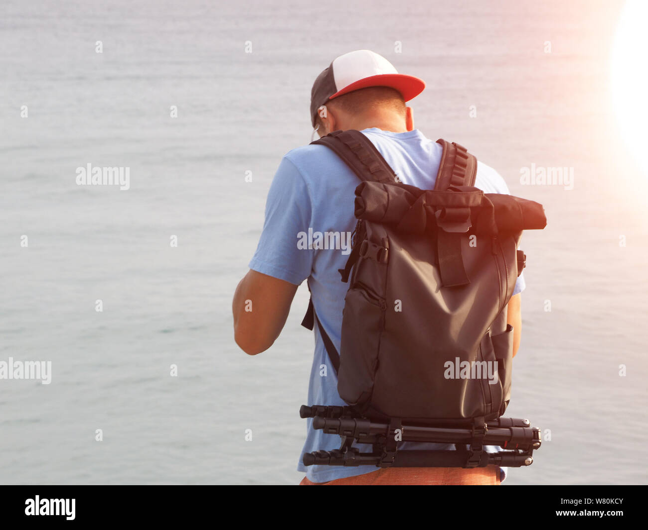 a man with a backpack photographic equipment on a stone beach. vacation ...