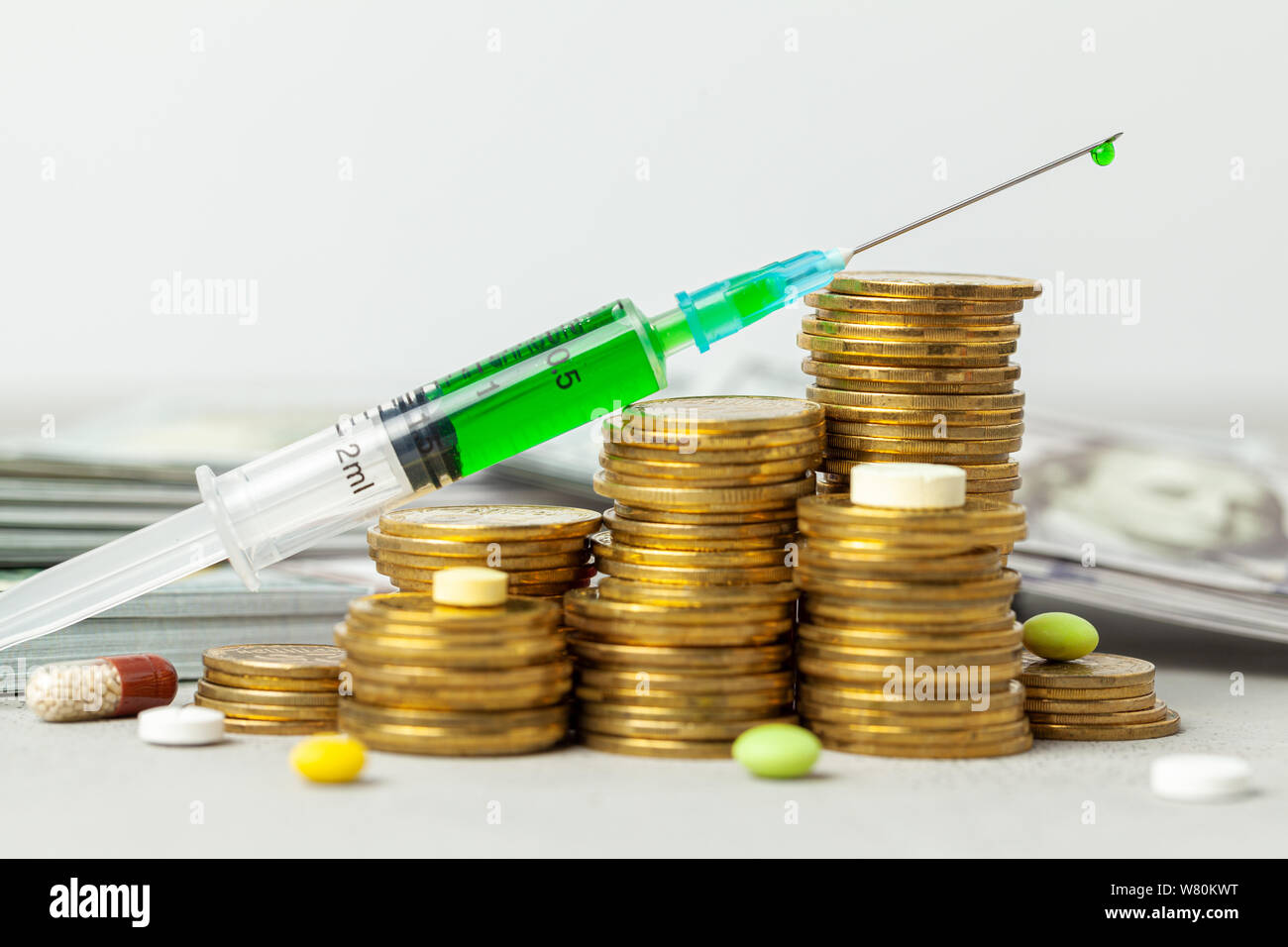 Stack of coins by staircase symbol of growth and pills with syringe ...