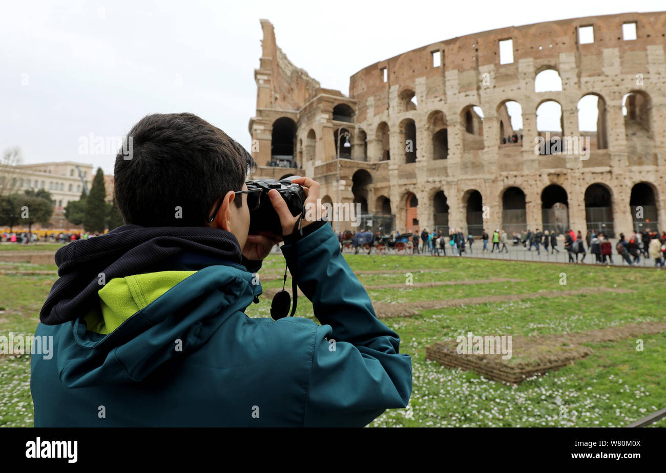 Young boy takes pictures in Rome and the Colosseum in background Stock ...