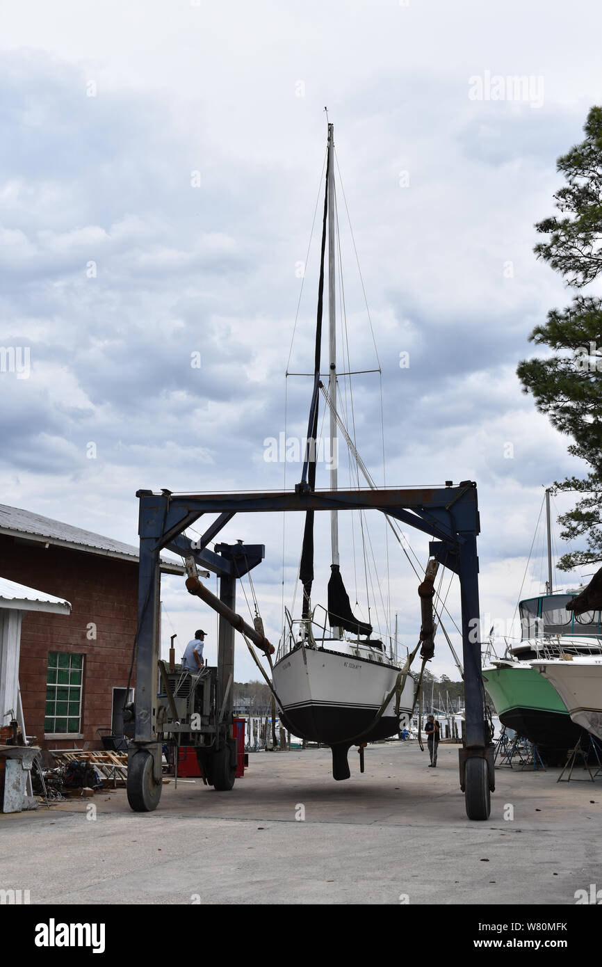 A Sailboat being pulled out of the water with a boat hoist Stock Photo ...