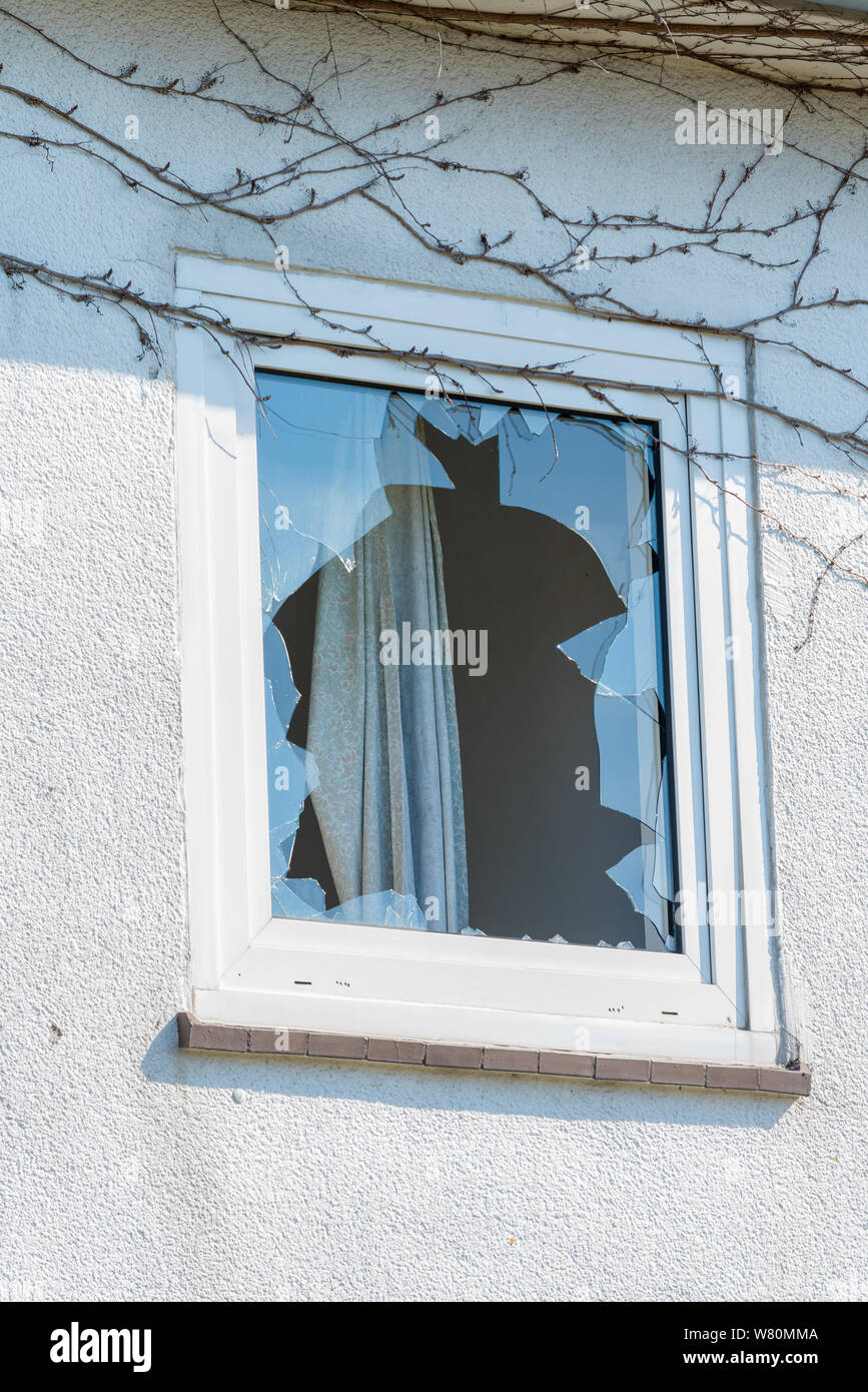 Broken window in a building. The concept of vandalism Stock Photo - Alamy
