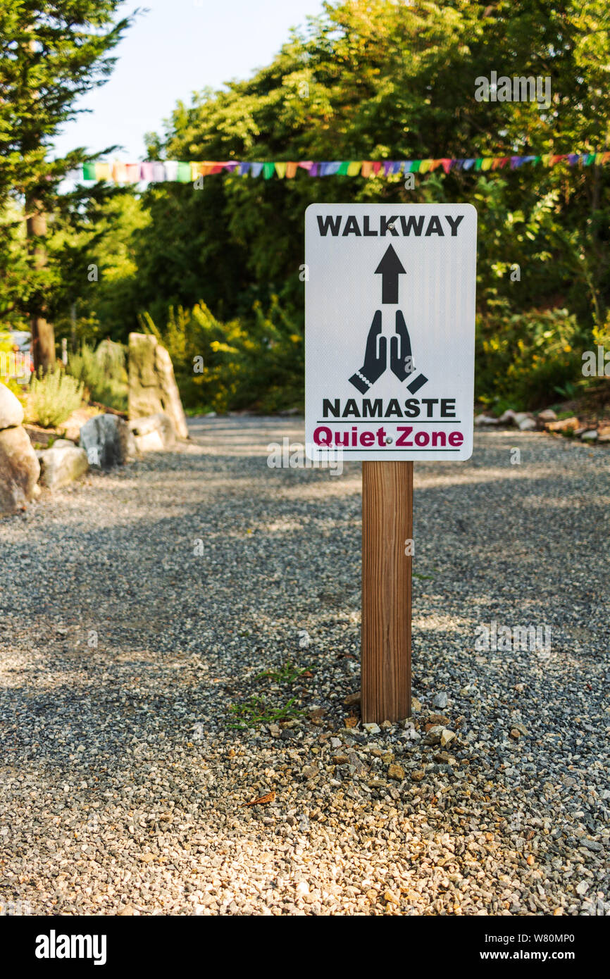 A sign on a walkway to a yoga studio proclaims "Namaste, Quiet Zone ...