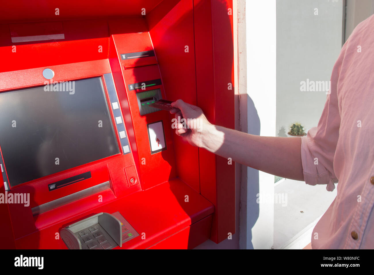 Hand of a man with a credit card, using an ATM. Man using an atm ...