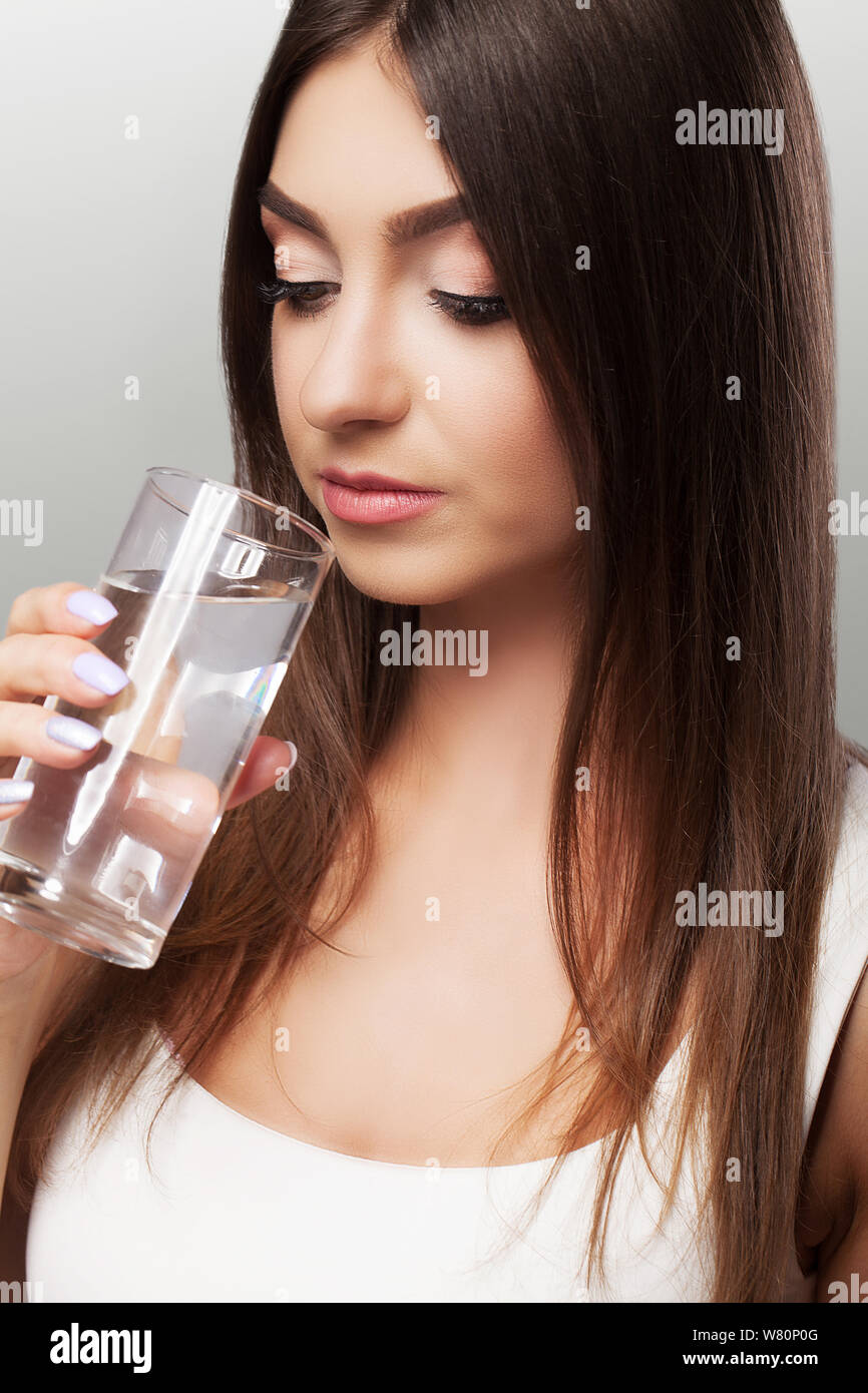 Drink water. Young girl drinking water from the glass. Daily water ...