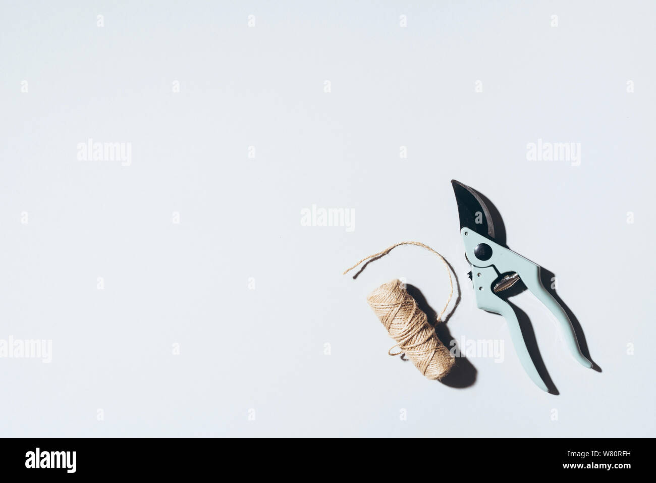 Branch pruner and craft linen threads over grey background. Gardening ...