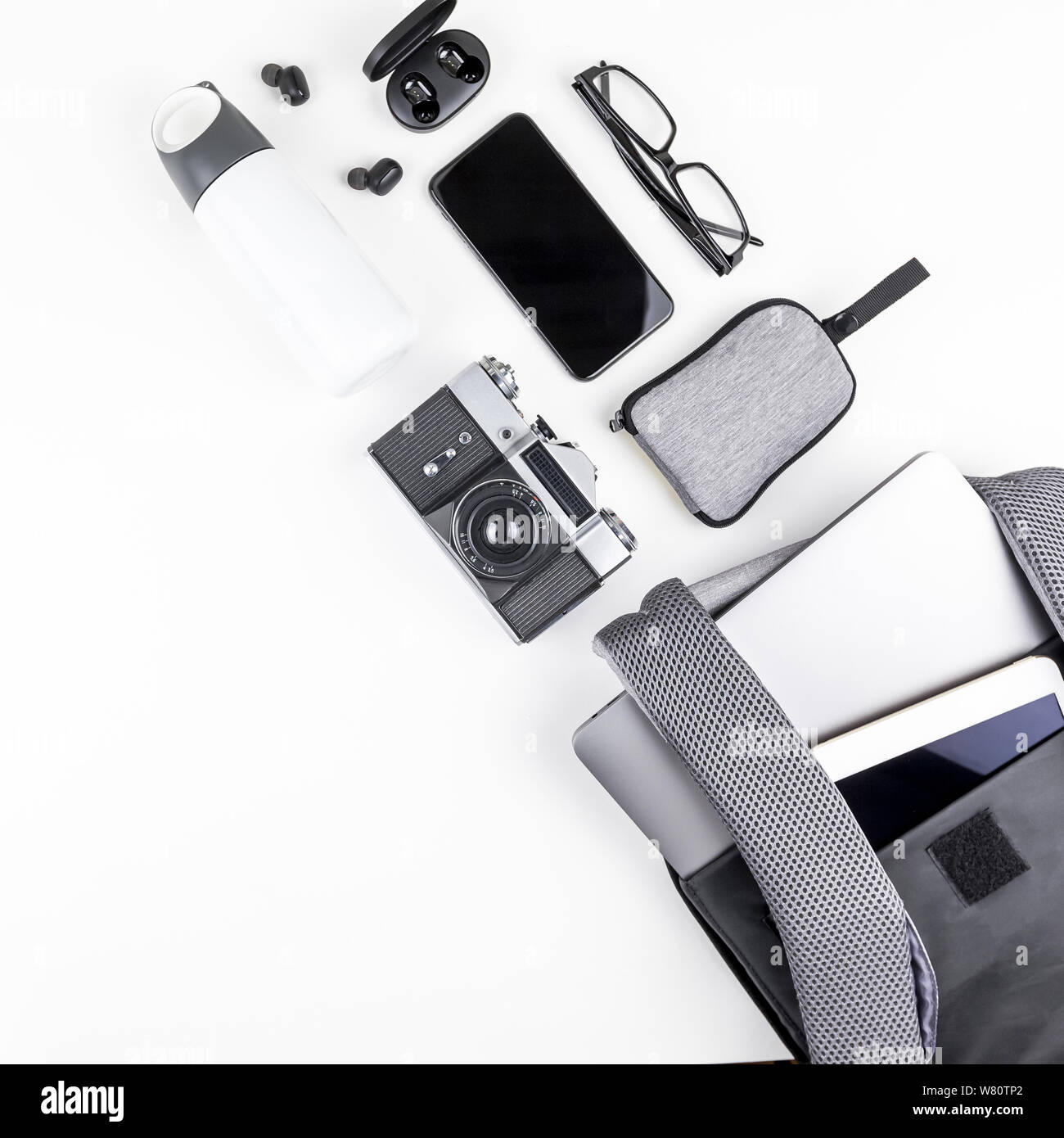 Creative top view flat lay of open backpack with laptop and tablet ...