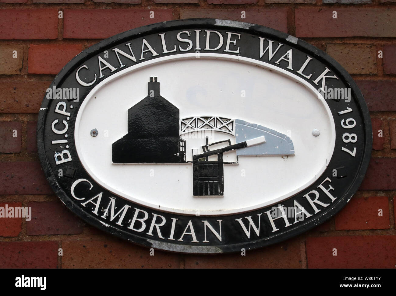 Canalside walk oval plaque on brick wall by canal at Cambrian Wharf in ...