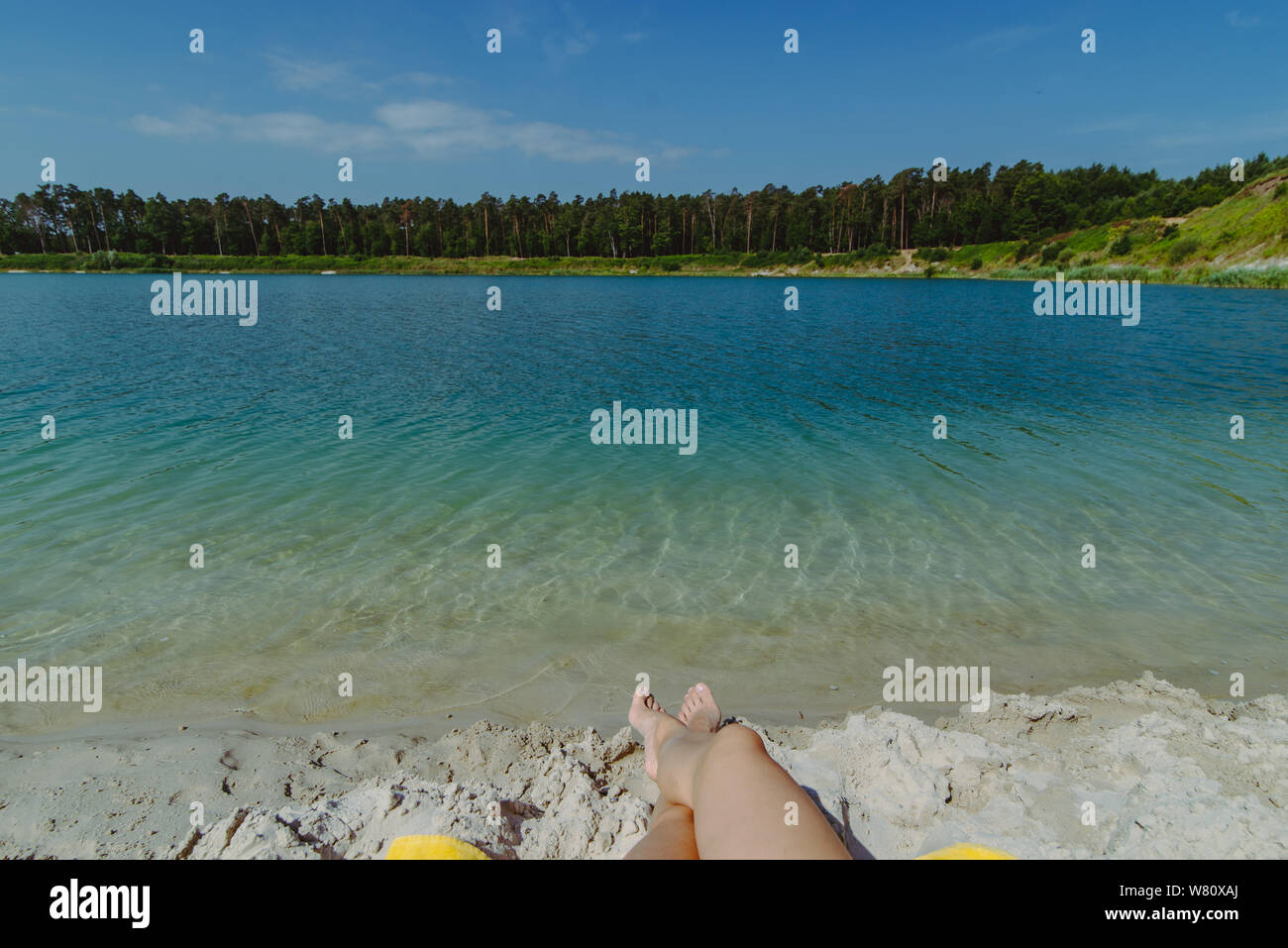 point of view woman legs at sand beach looking at blue clear water copy ...