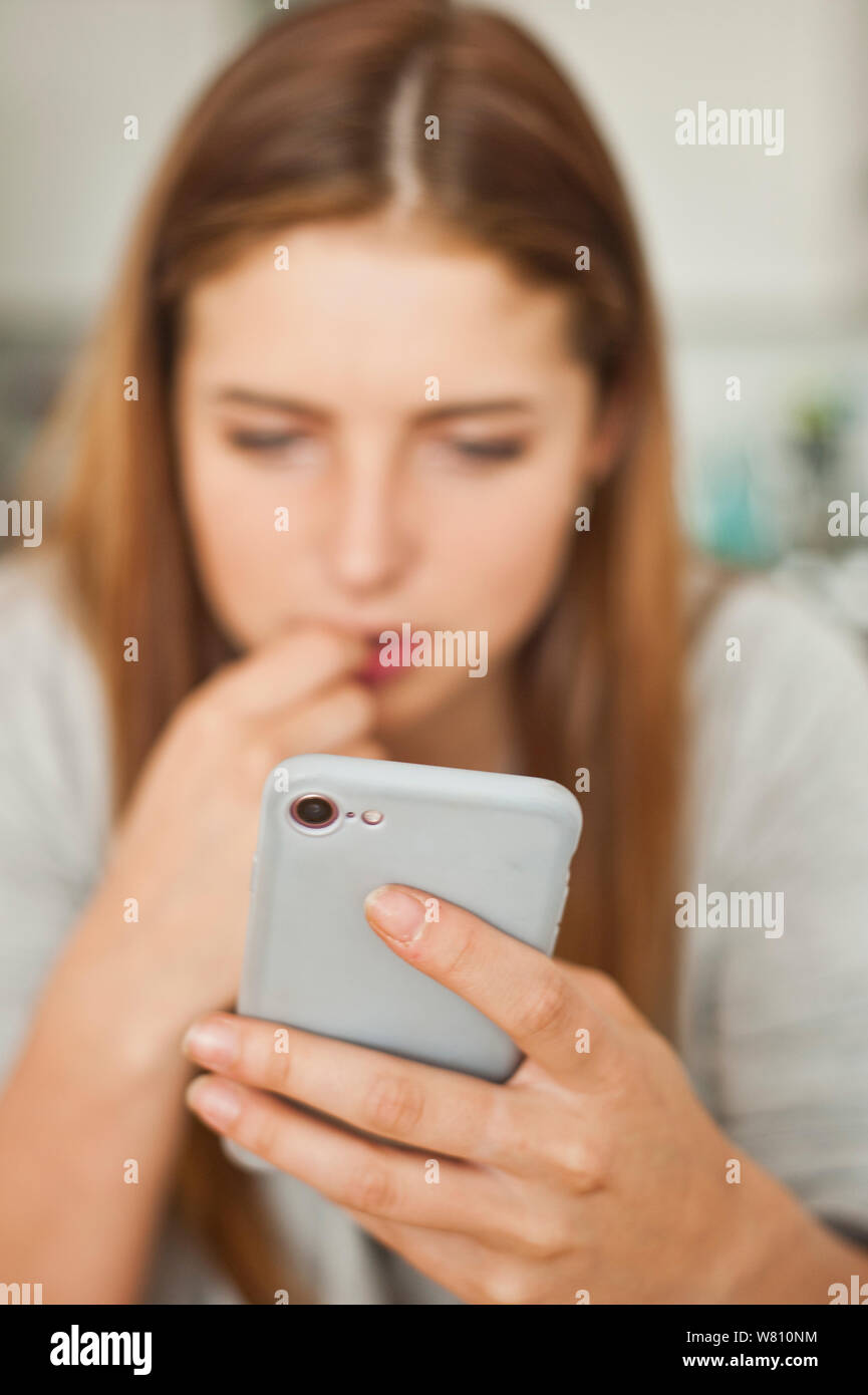 brunette teenager girl looking at the screen of her smartphone Stock ...