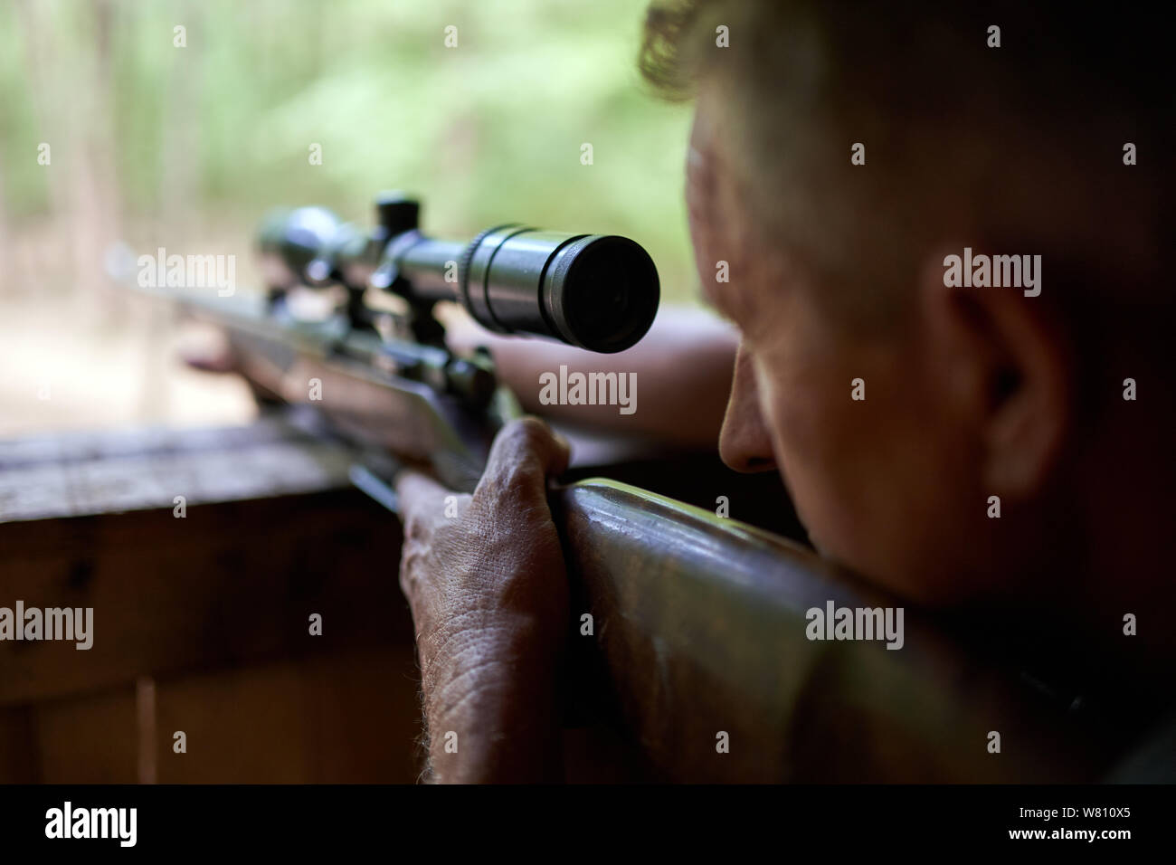 Game ranger with gun at the feeding spot for wild animals Stock Photo ...