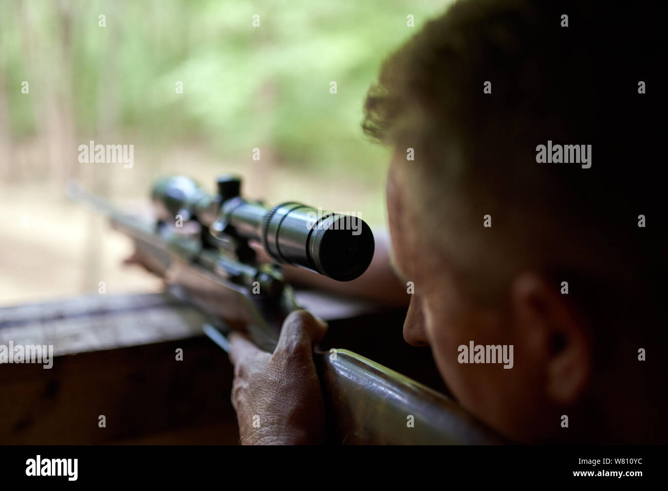 Game ranger with gun at the feeding spot for wild animals Stock Photo ...