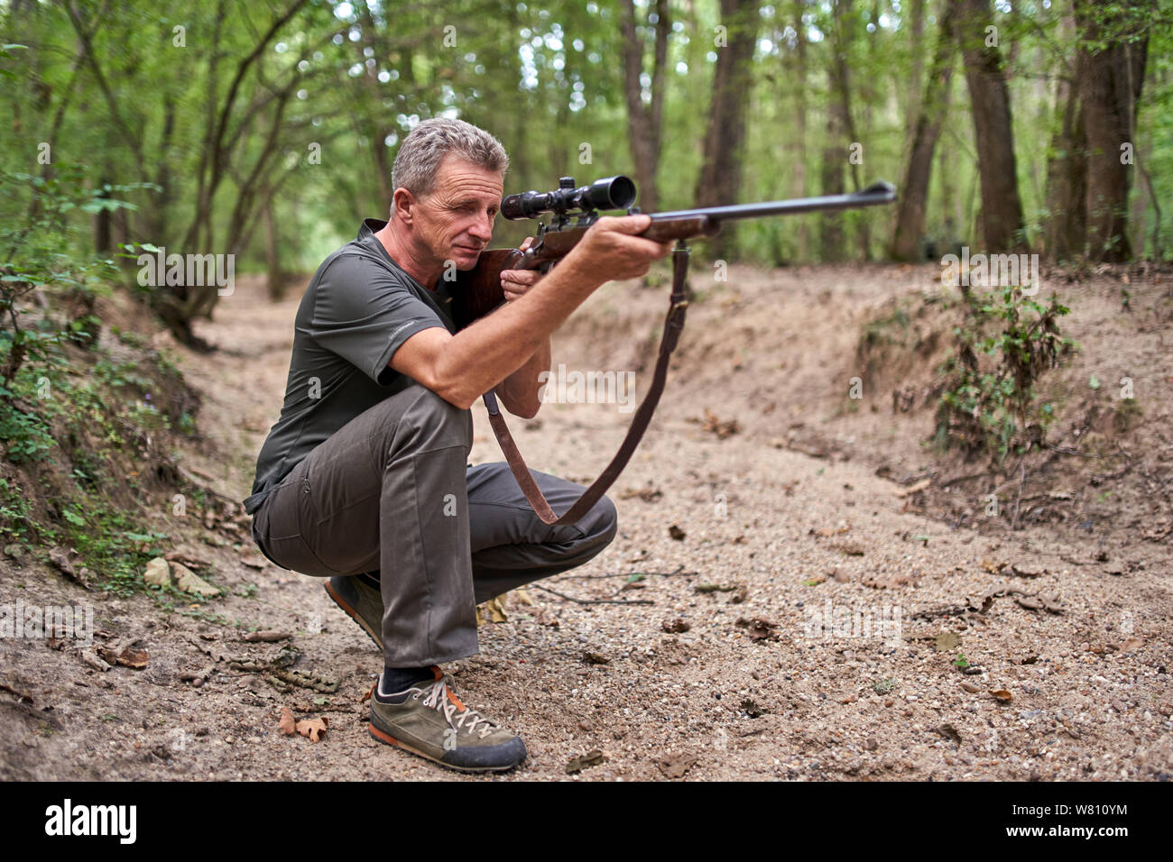 Hunter with rifle in the forest Stock Photo - Alamy
