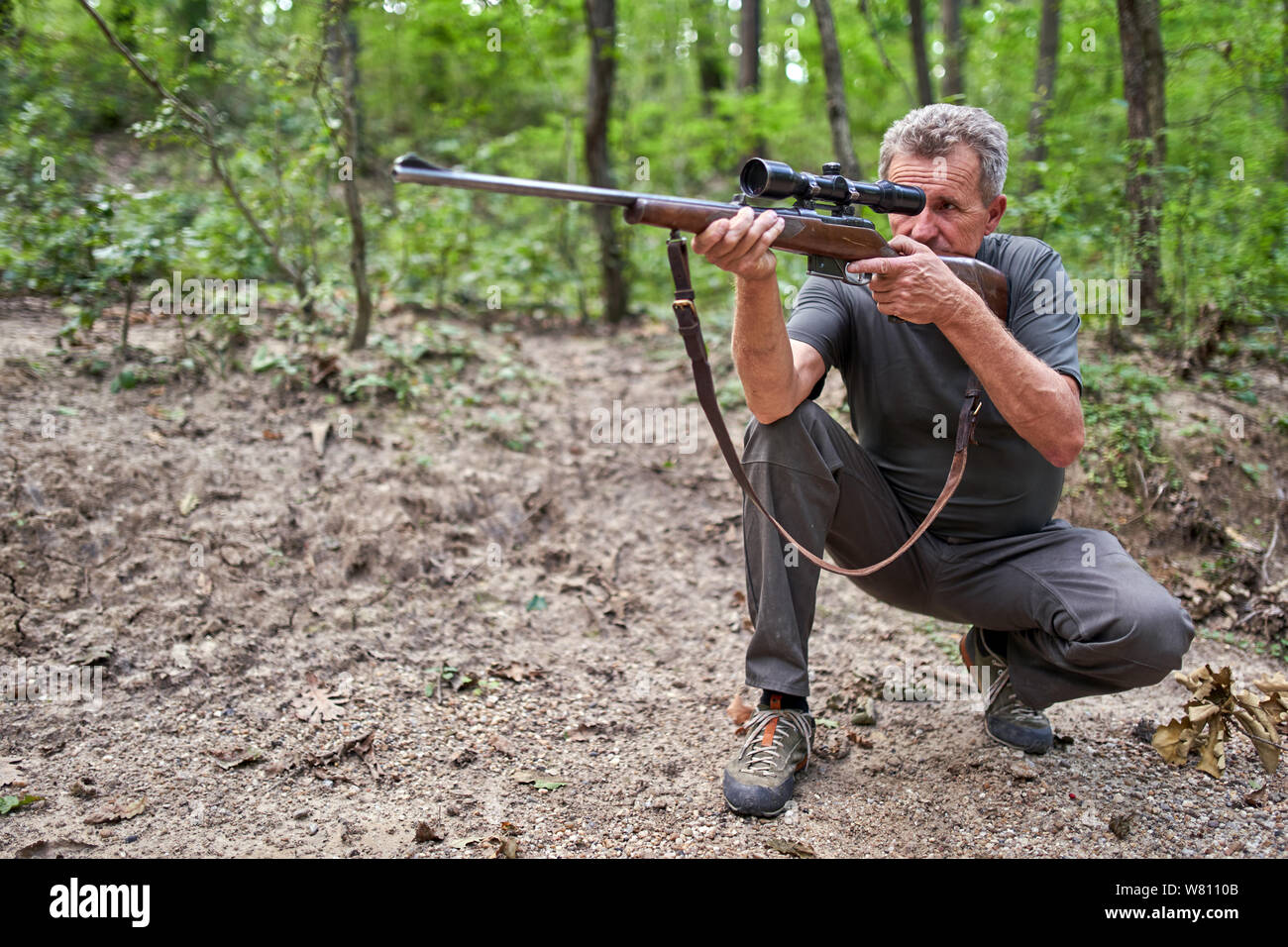 Hunter with rifle in the forest Stock Photo - Alamy