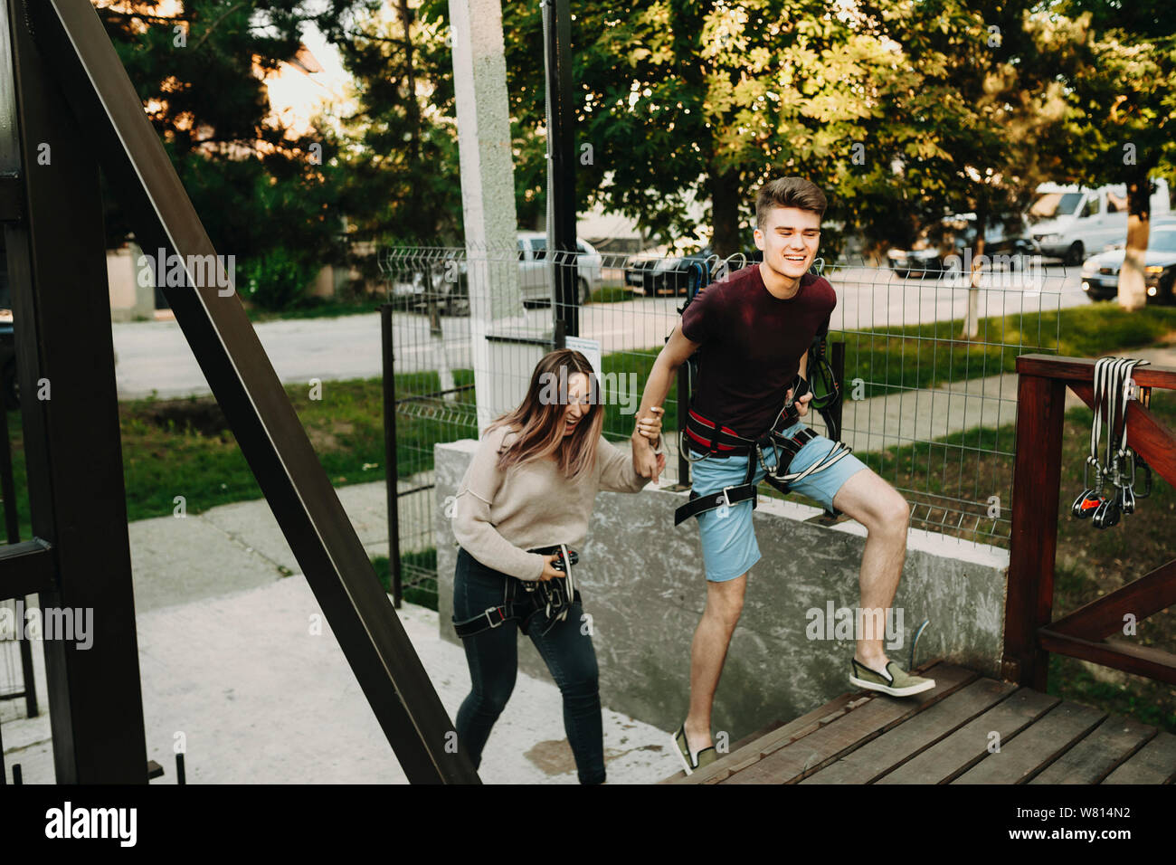 Lovely happy caucasian couple running on a zipline platform while ...