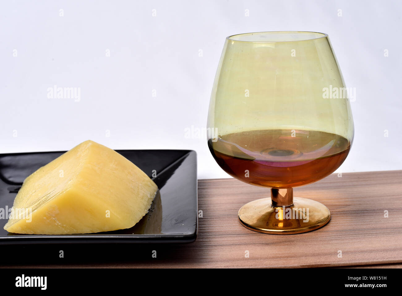 glass of alcoholic drink with cheese on the table on white background ...