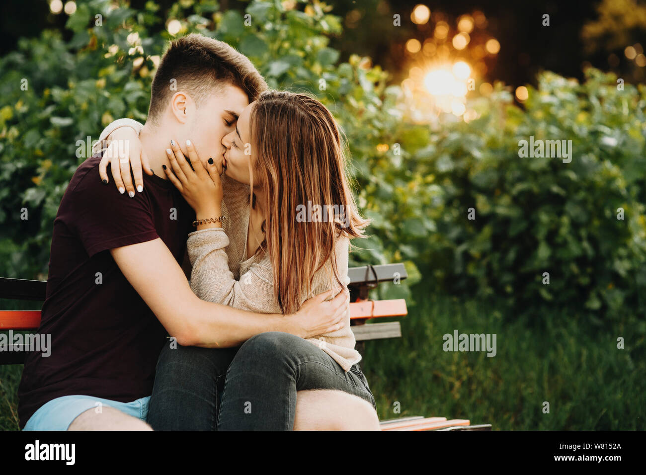 Young couple kissing on park bench hi-res stock photography and images ...
